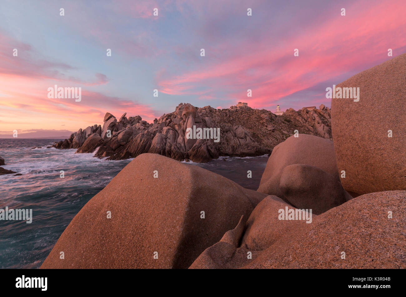 Pink sky at sunset frames the lighthouse on cliffs Capo Testa Santa ...