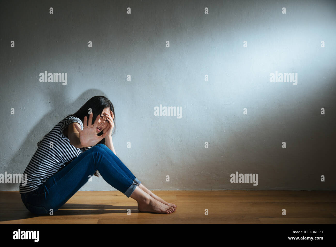 innocence woman sitting on wood floor hand cover head and showing stop ...