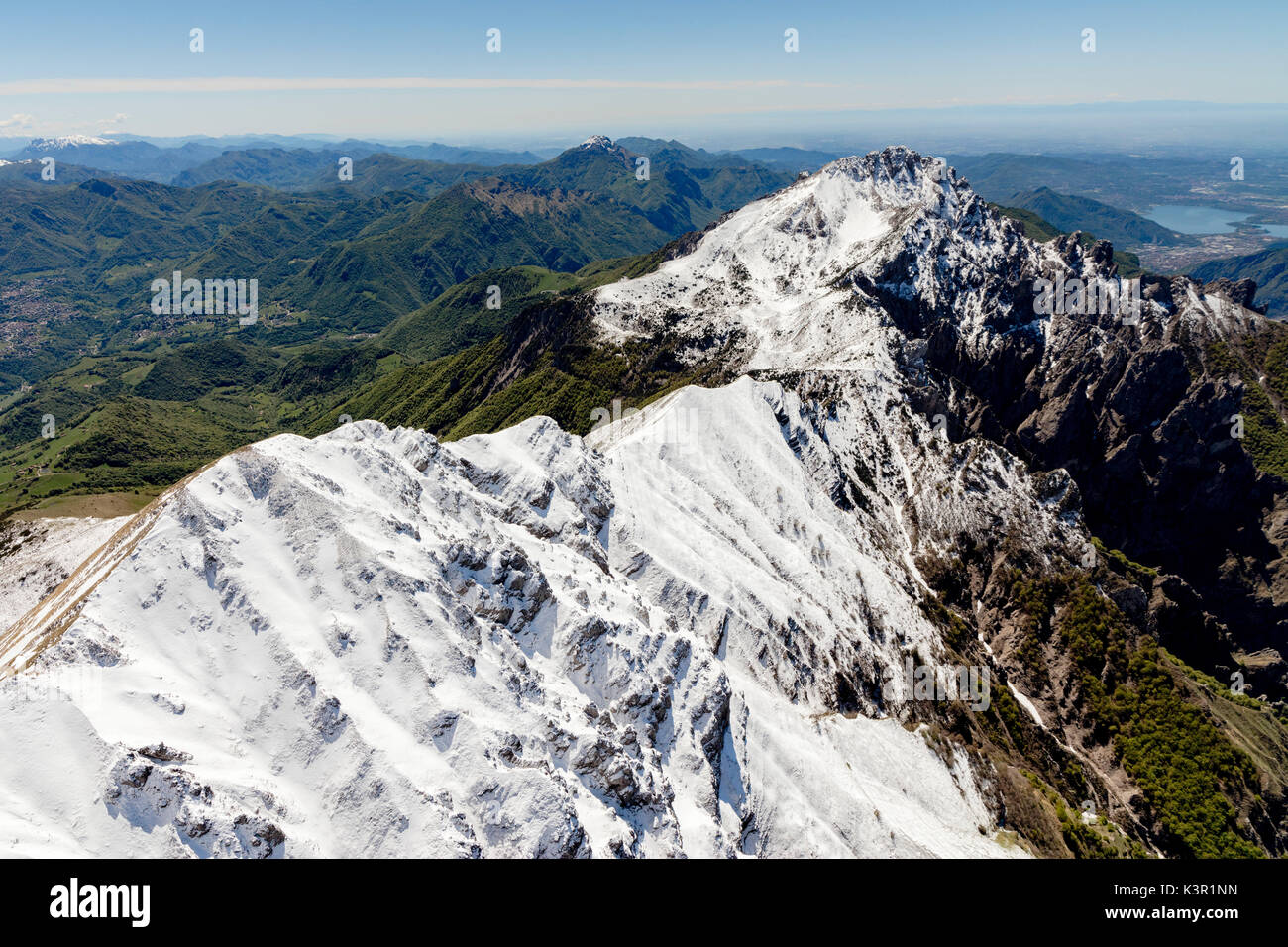 Aerial view of the snowy ridges of Grignetta and Resegone with the lake ...