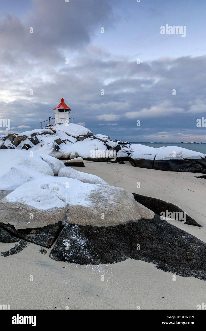The blue arctic dusk on the lighthouse surrounded by snow and icy sand ...
