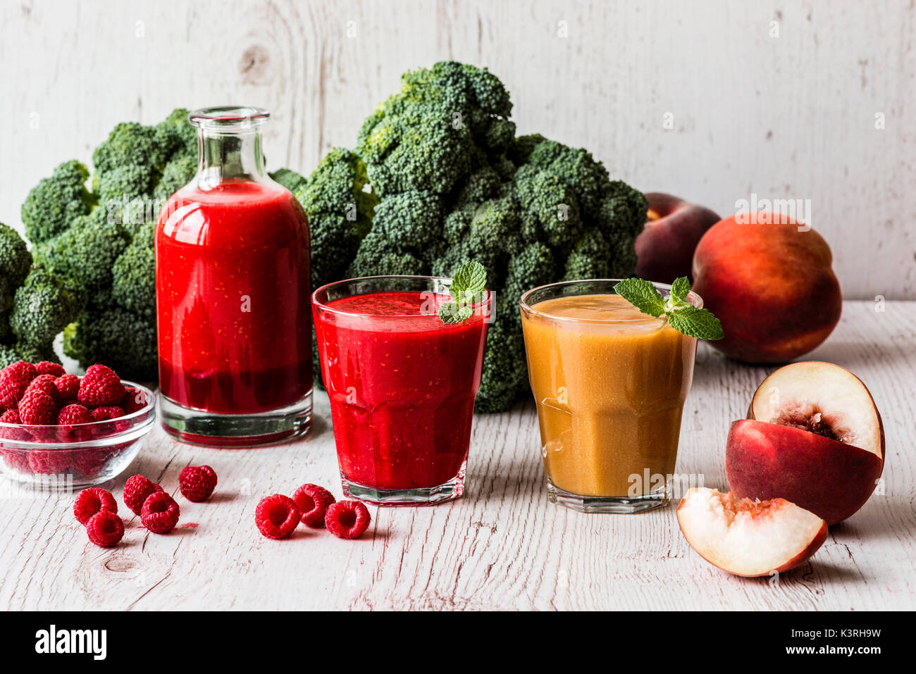 healthy drinks. raspberry fresh smoothie in glass and bottle and peach ...