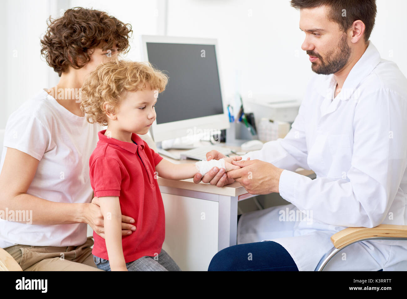 Portrait of curly little kid with injured arm at doctors office Stock ...