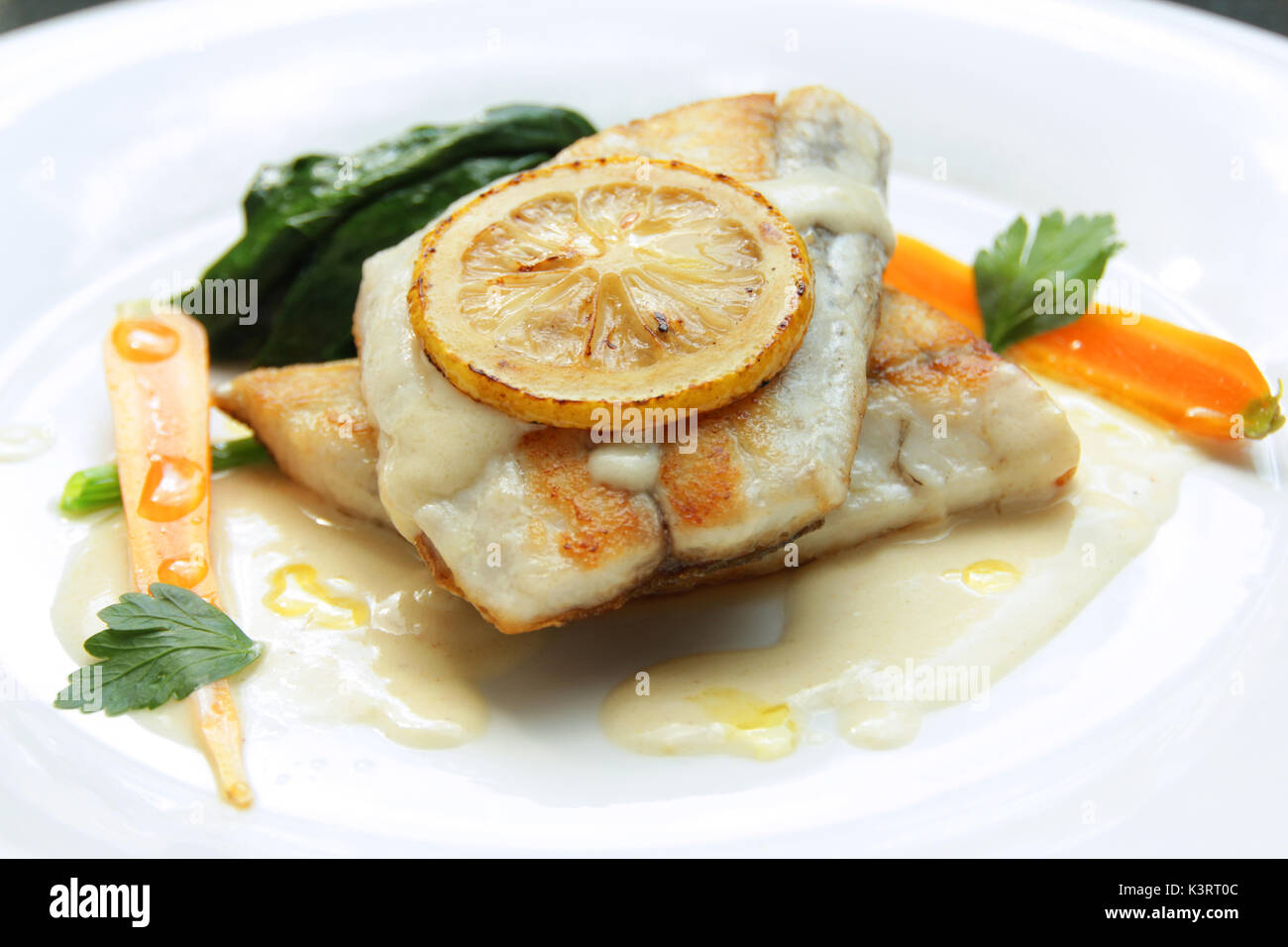 snow fish grilled topping with roasted lemon serve with white sauce ...
