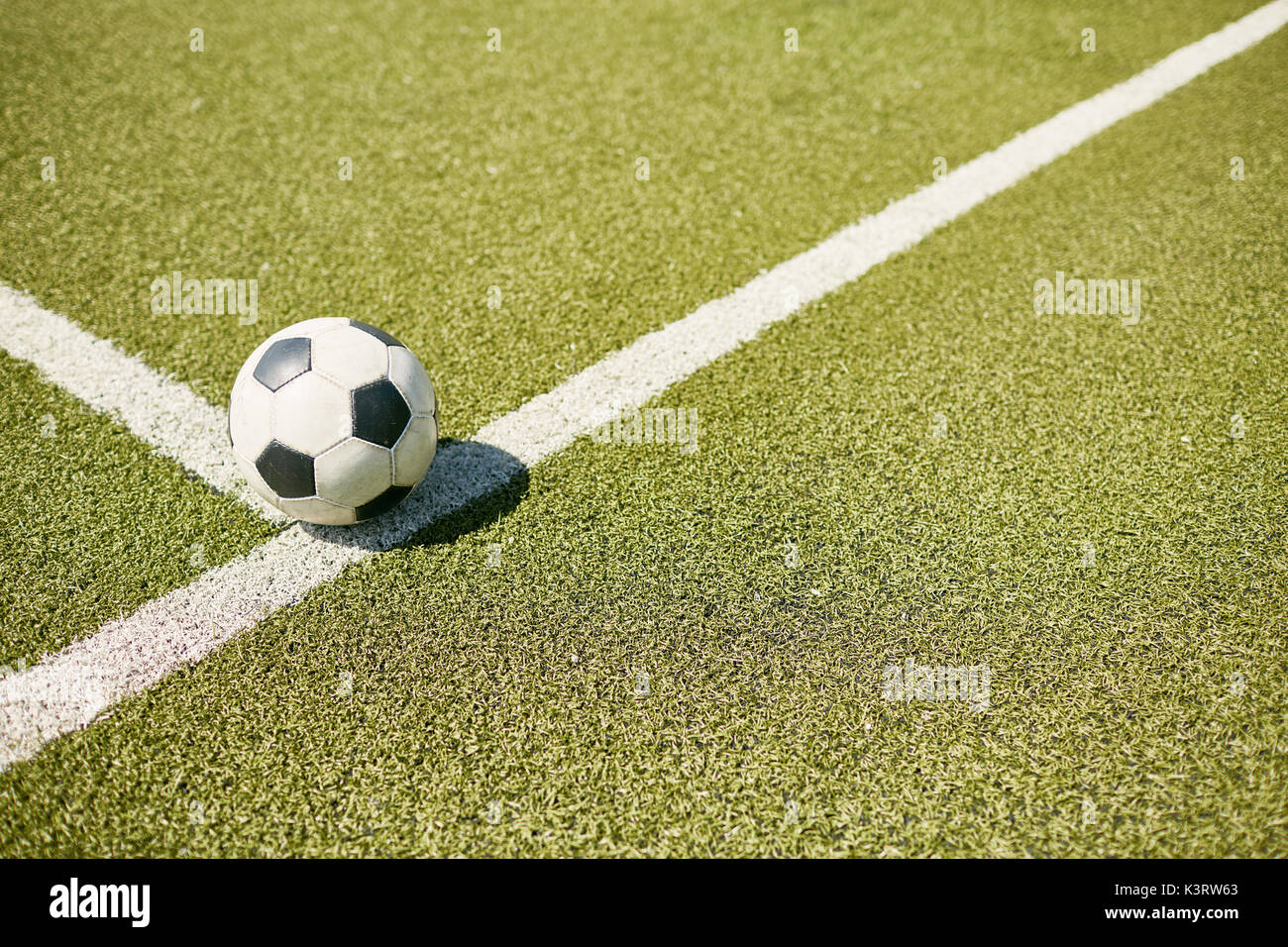 High angle closeup of ball lying on green football field, copy space ...