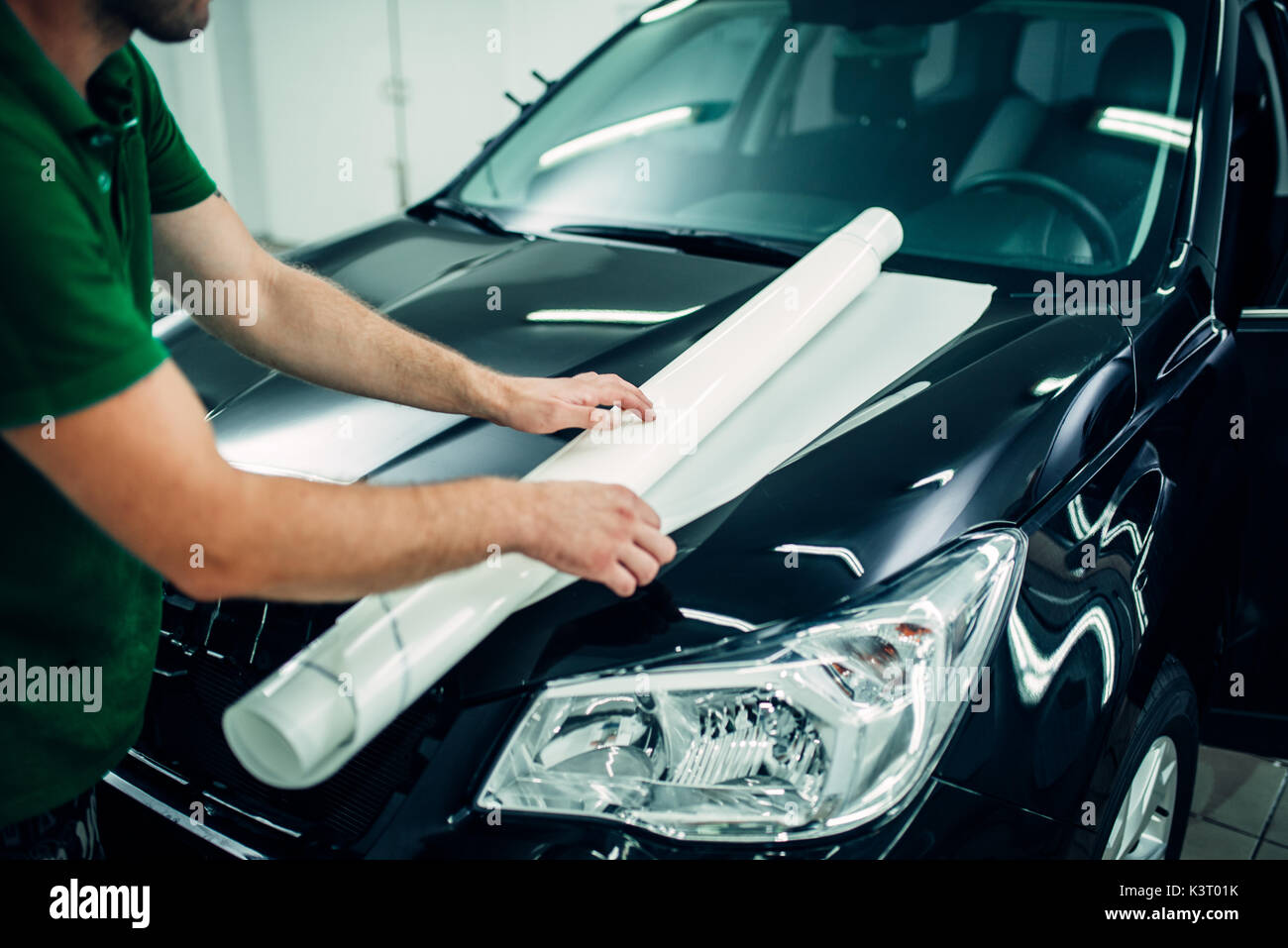 Paint protection film installation, hood protect. Worker hands prepares ...