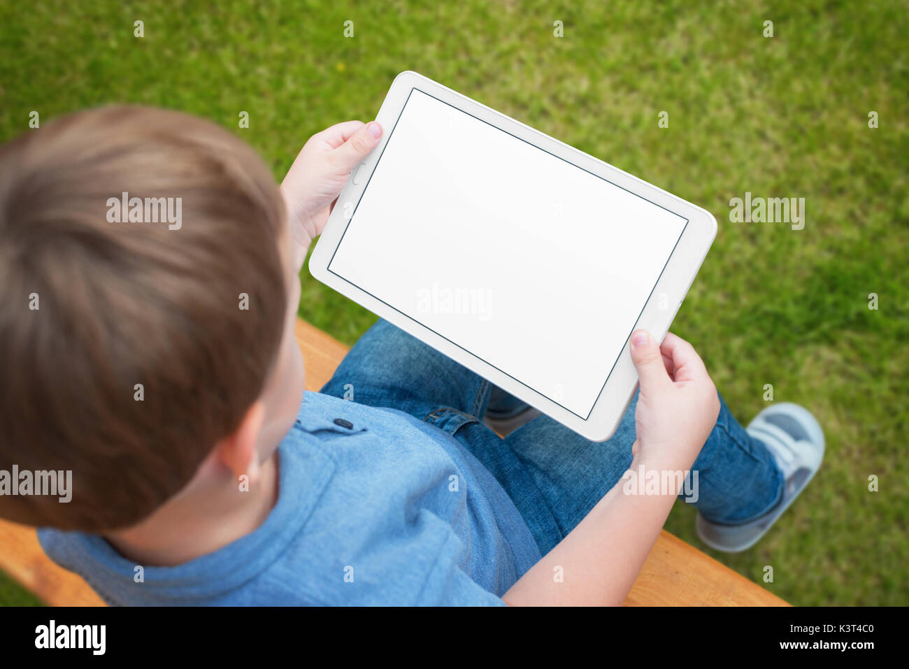Boy use tablet with isolated white screen for mockup. Child playing ...