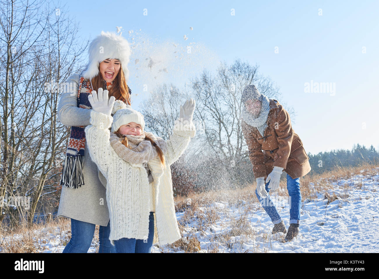 Family playing snowballl fight and having fun in winter Stock Photo - Alamy