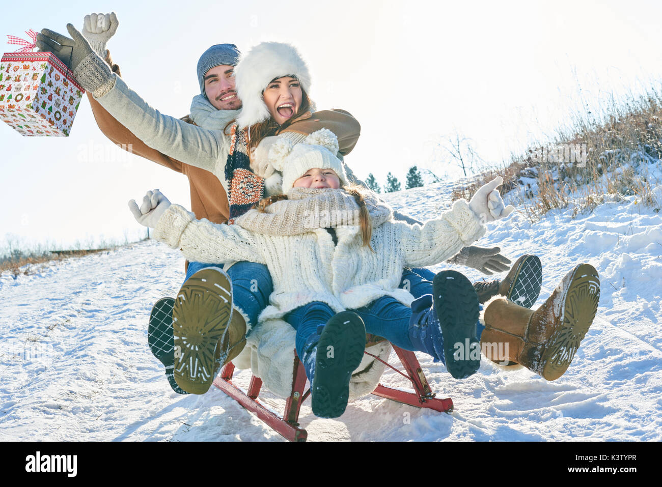 Family have fun with sled in winter and driving with christmas present ...