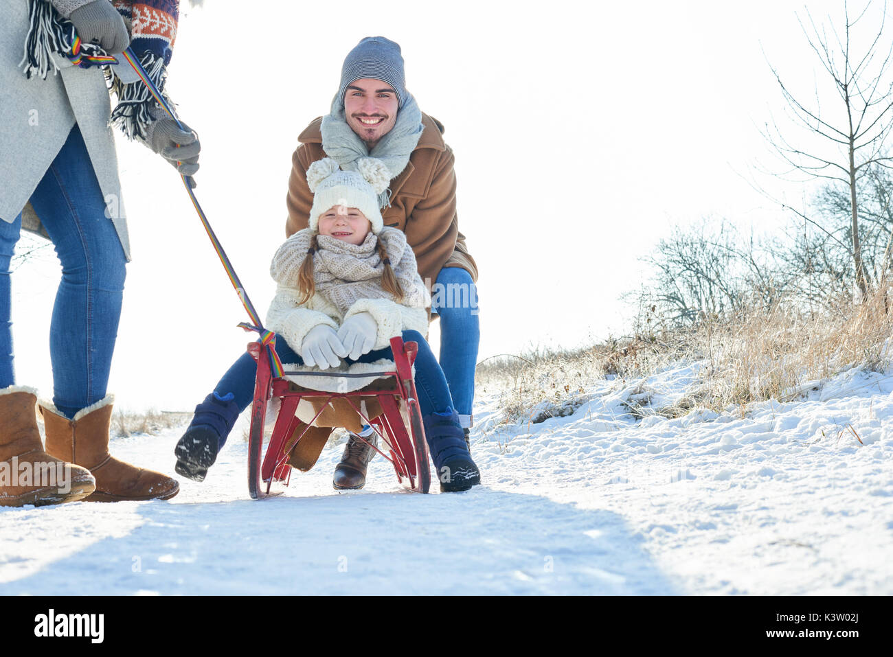 Family with child on sled having fun in winter Stock Photo - Alamy