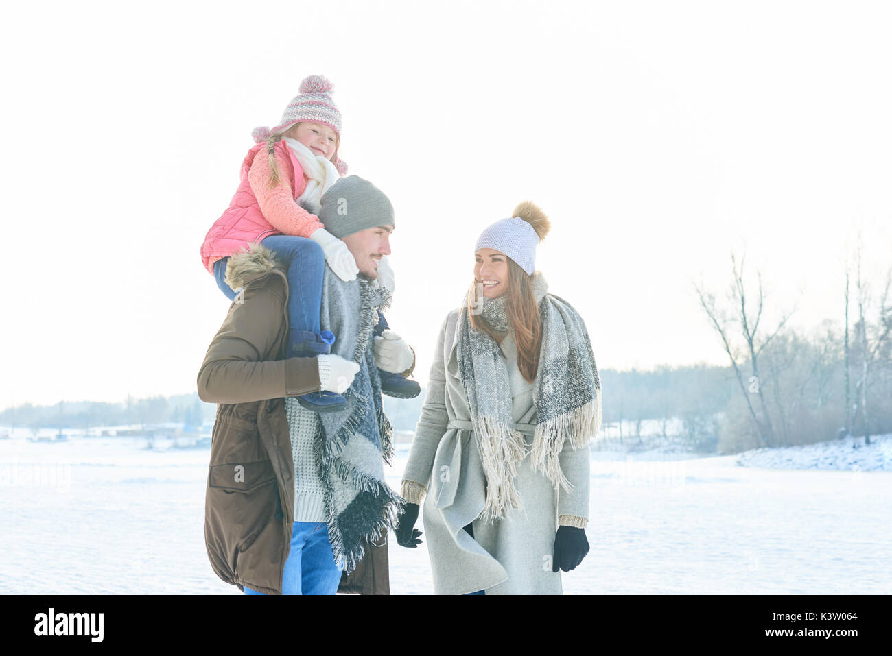 Parents with child as family in winter taking a walk with a piggyback ...
