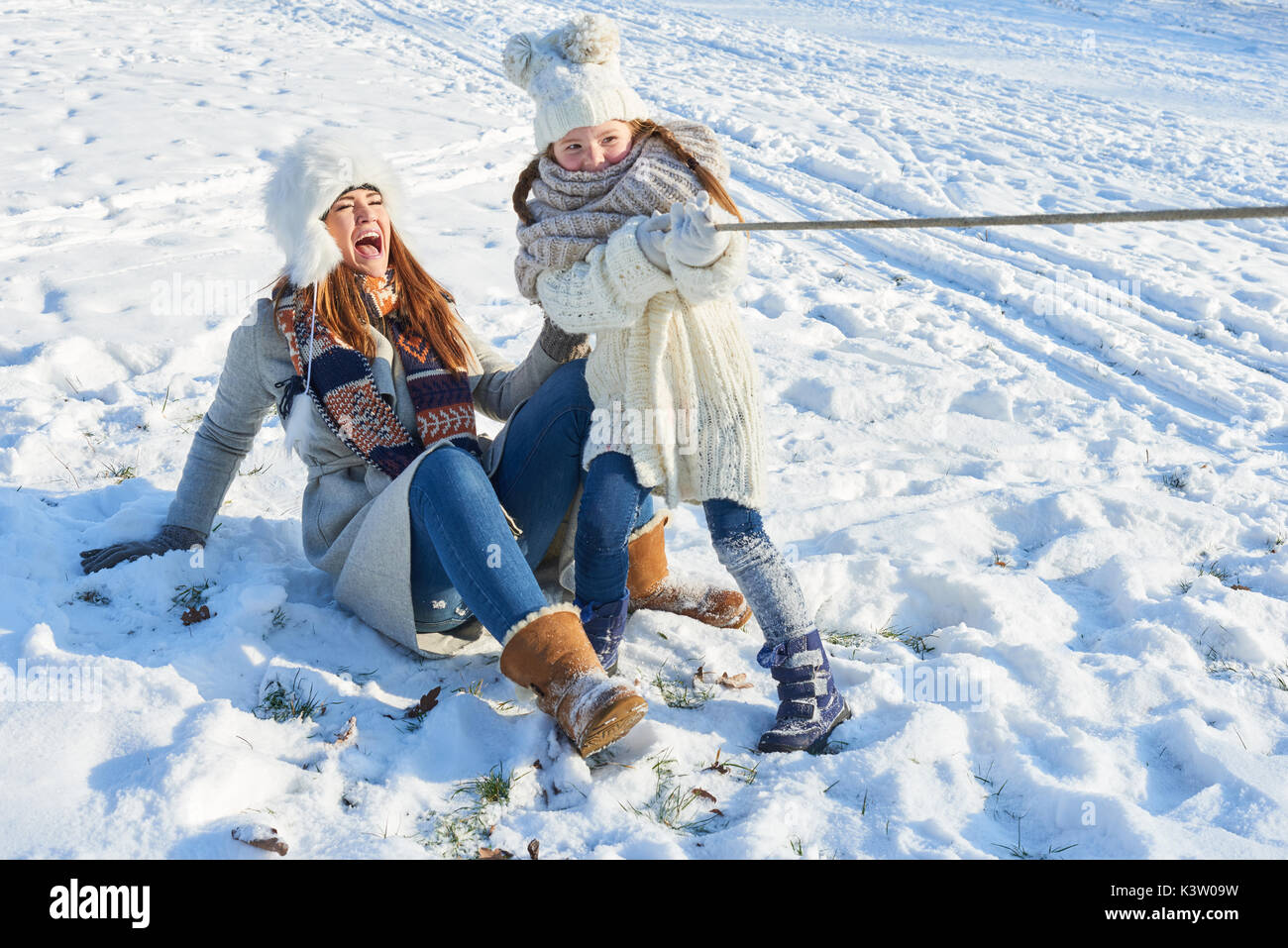 Child and mother play tug of war with power in winter Stock Photo - Alamy