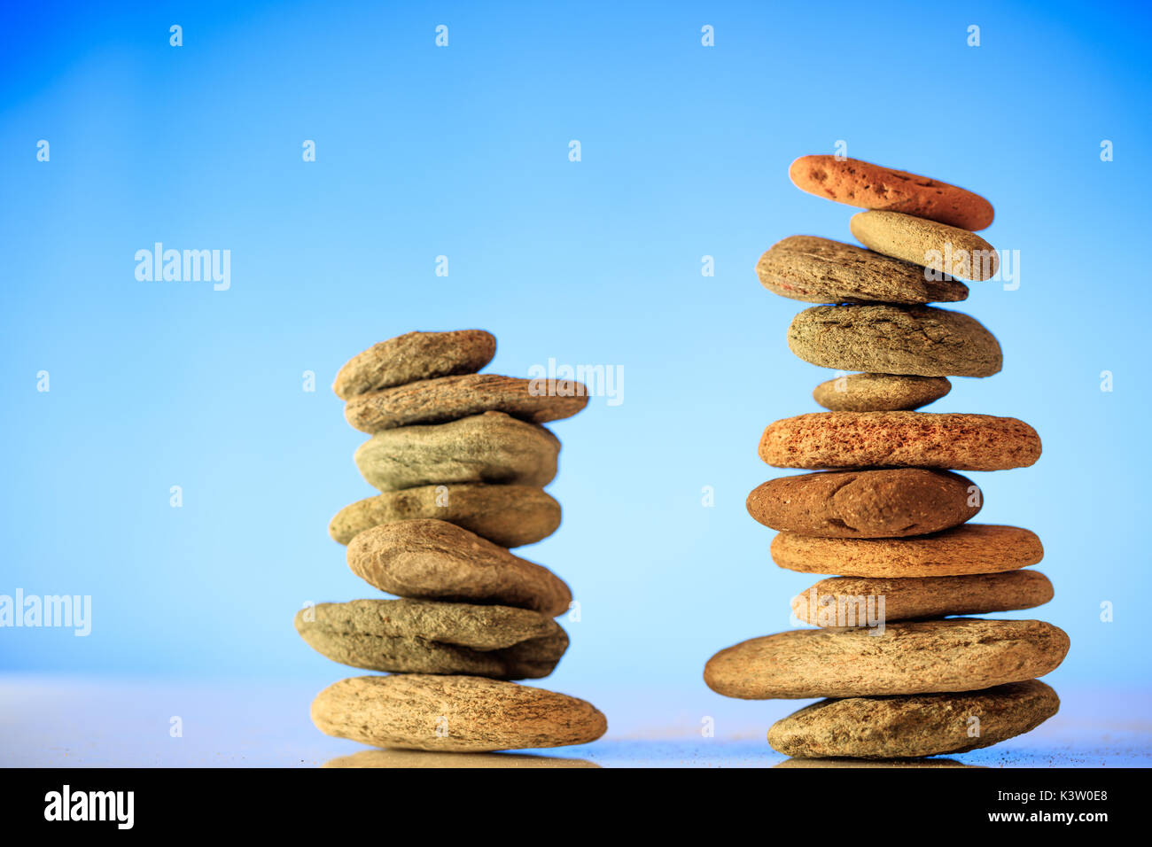 Zen stones stacked on light blue background Stock Photo - Alamy
