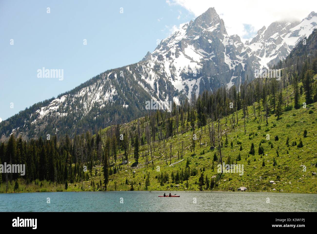 Kayakers row along String Lake in front of the Teton Range mountains at ...