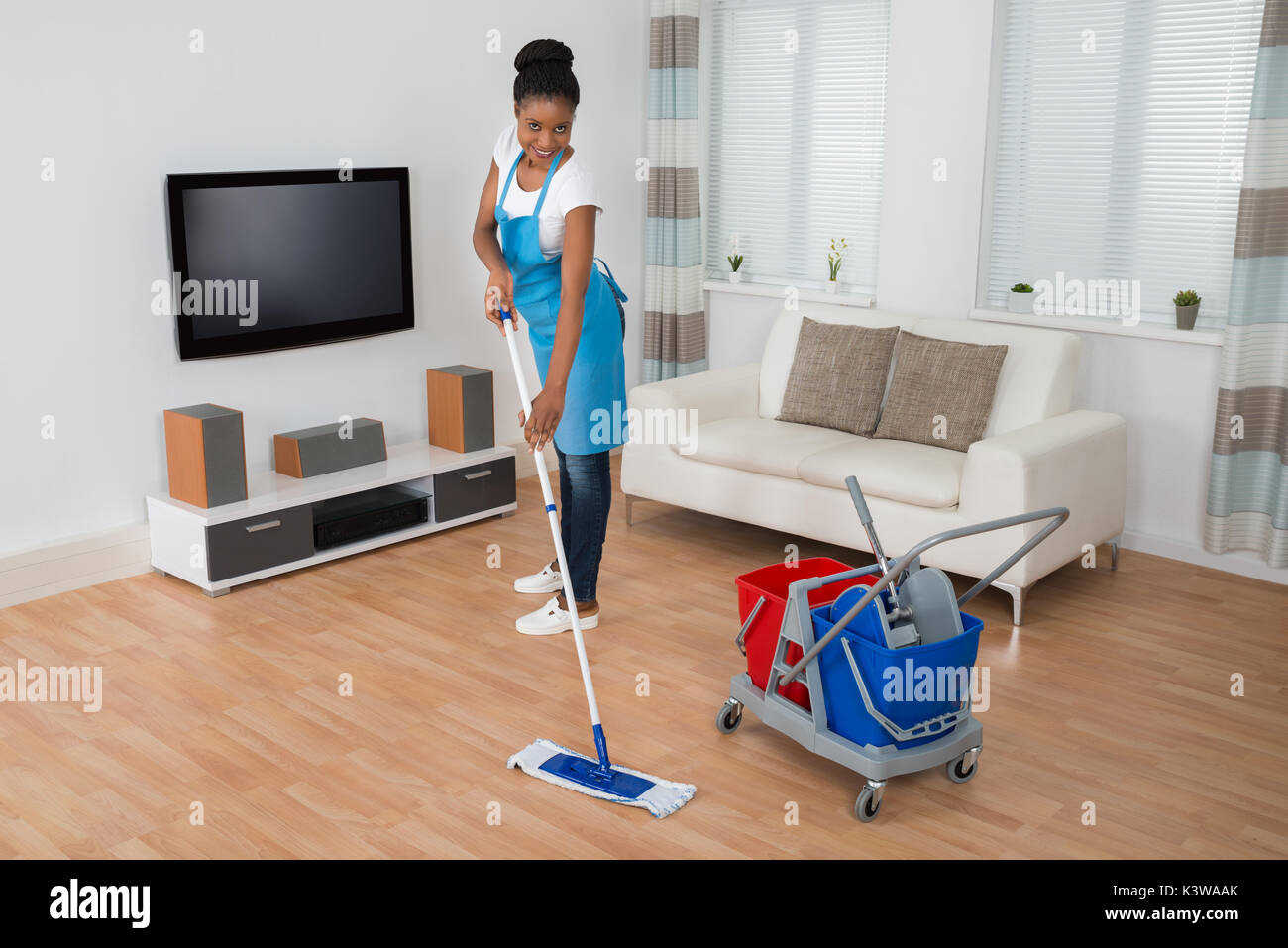 Smiling Young African Woman Cleaning Floor With Mop Stock Photo - Alamy