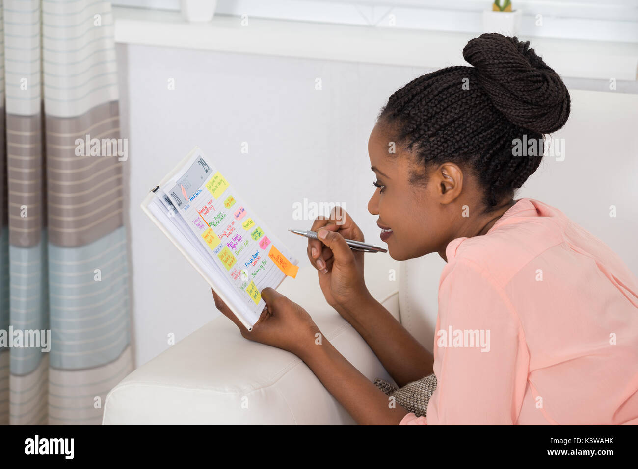 Smiling Young African Woman Checking Schedule In Diary Stock Photo - Alamy