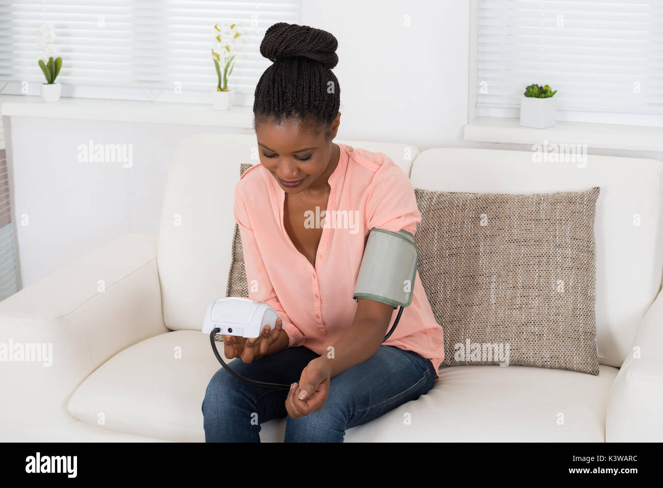 Young African Woman Checking Blood Pressure At Home Stock Photo - Alamy