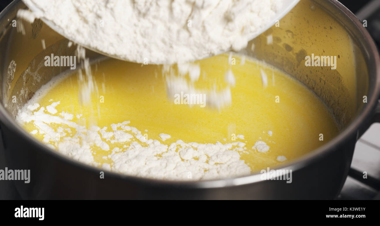 add flour to mix of melted butter with water Stock Photo - Alamy