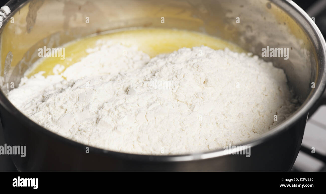 add flour to mix of melted butter with water Stock Photo - Alamy