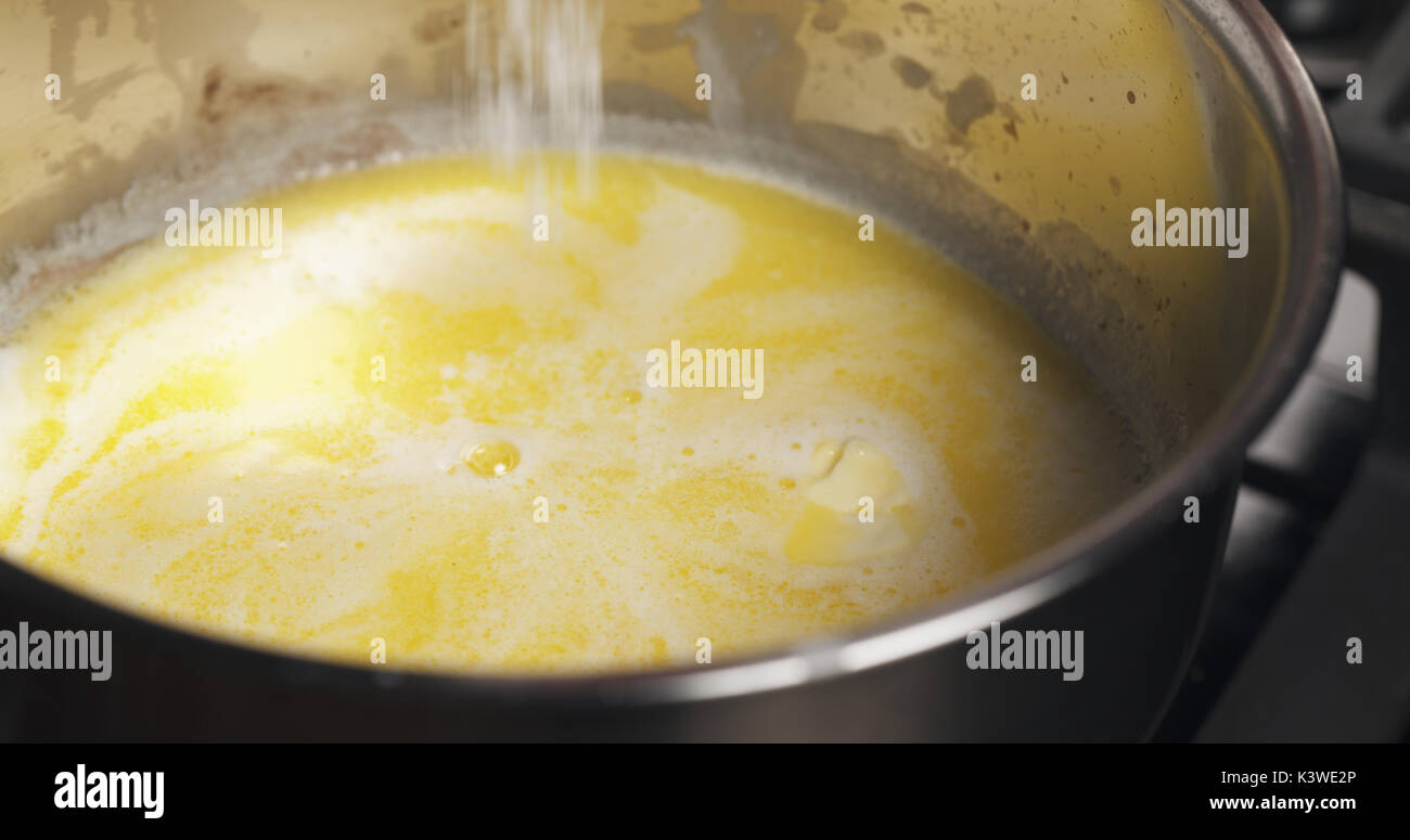 add salt to mix of melted butter with water Stock Photo - Alamy
