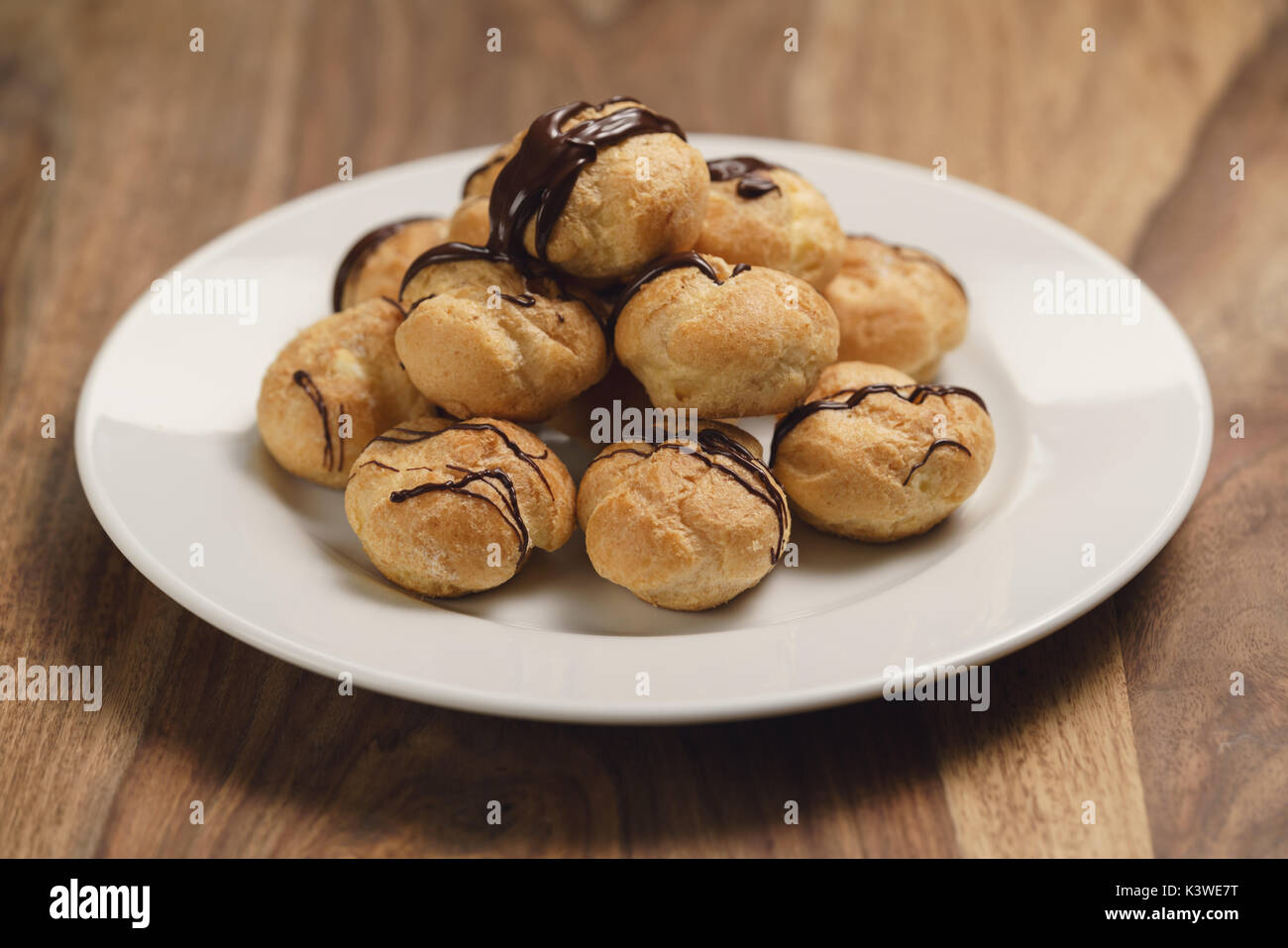 profiteroles with fine dark chocolate on plate Stock Photo - Alamy
