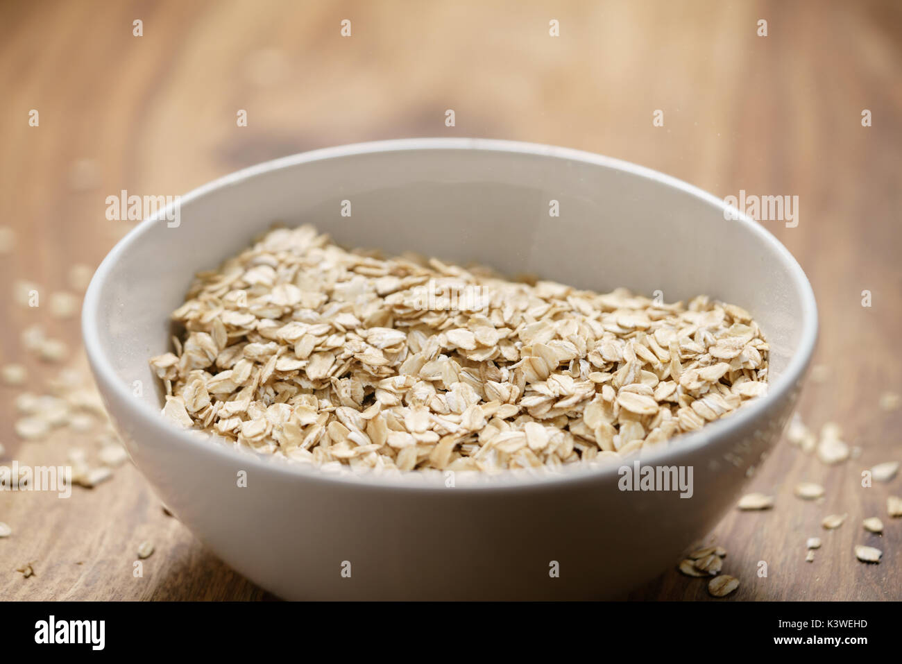 oat flakes in white bowl on wood table Stock Photo - Alamy