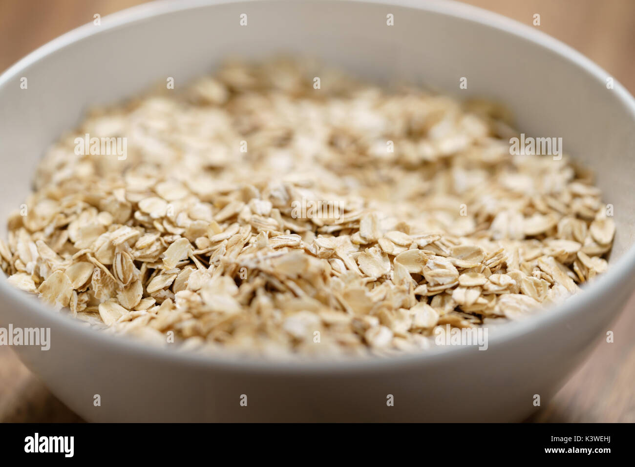 oat flakes in white bowl on wood table Stock Photo - Alamy