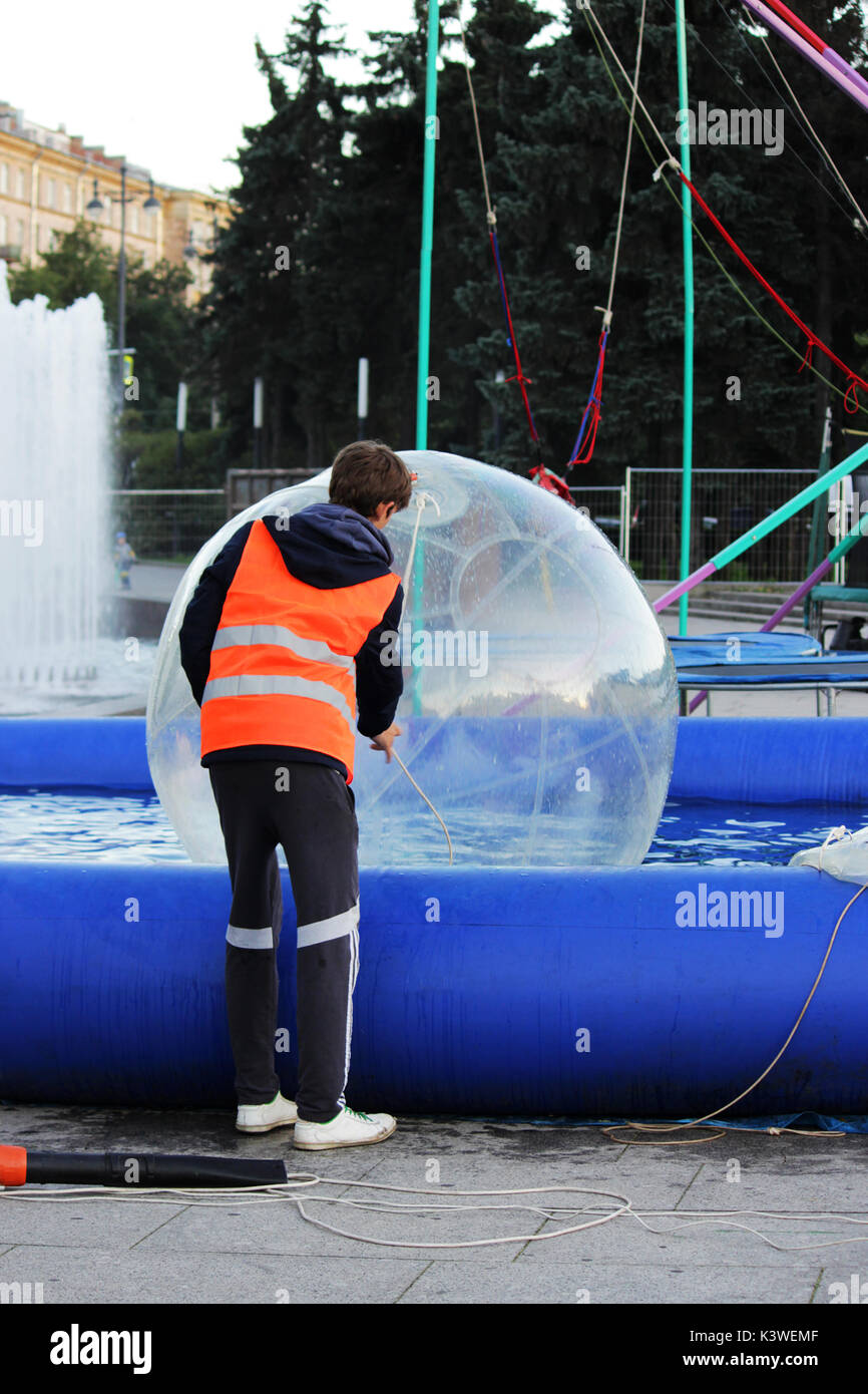 man prepares an inflatable ball for water zorbing in the pool Stock ...