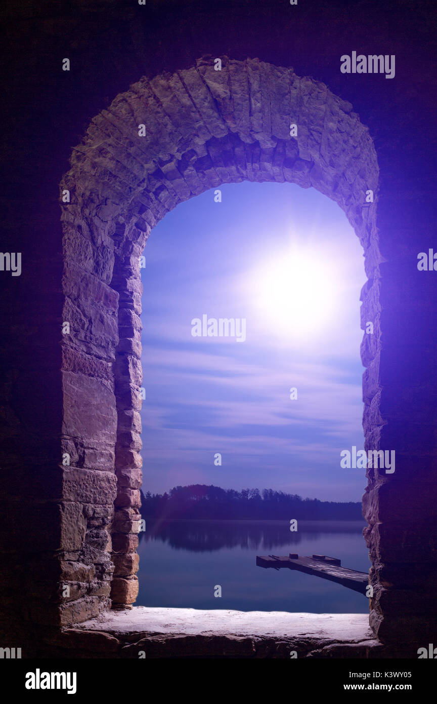 Evening night landscape with moon and lake visible through old ancient ...