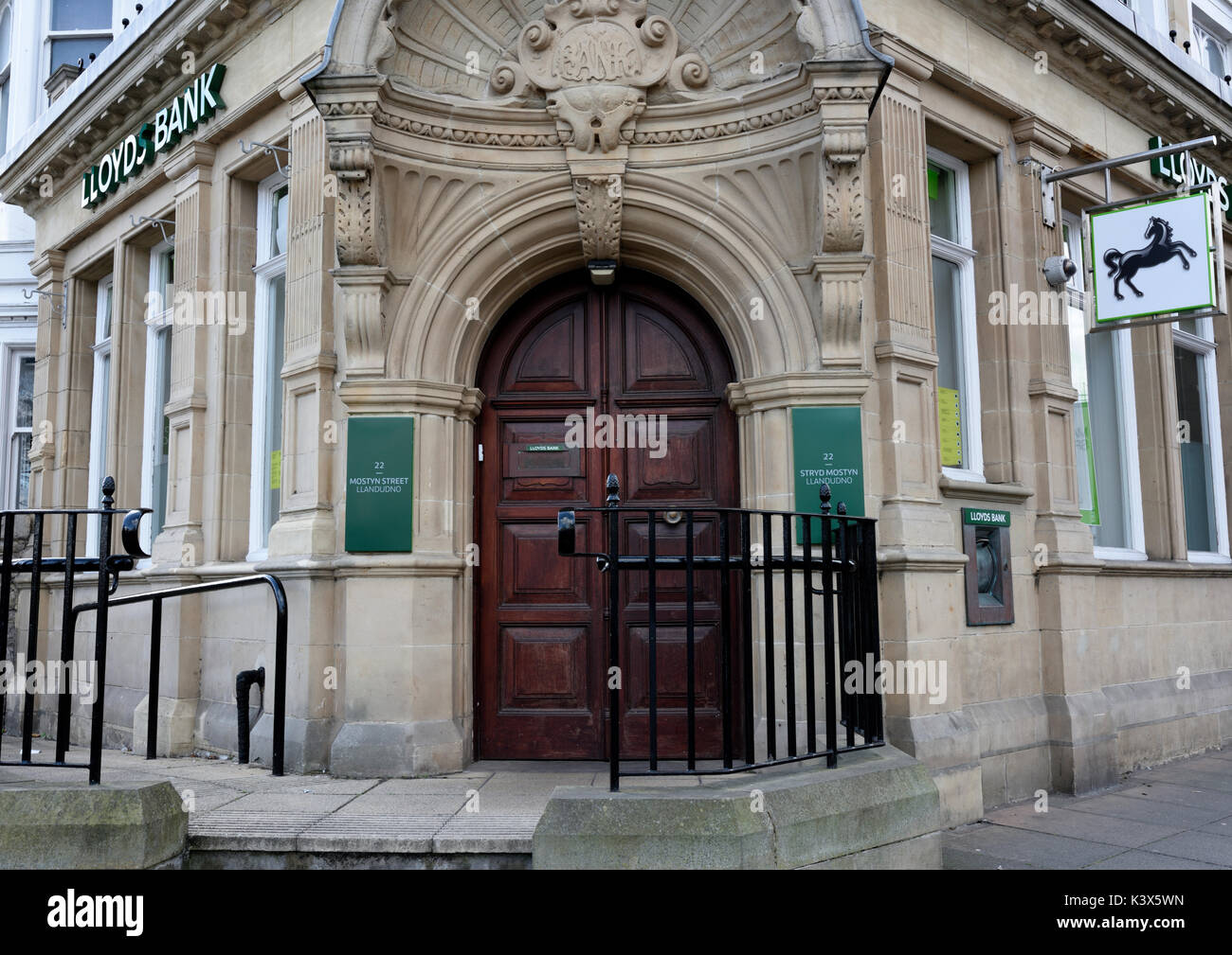 Stone arched doorway and double wooden doors on bank in llandudno north ...