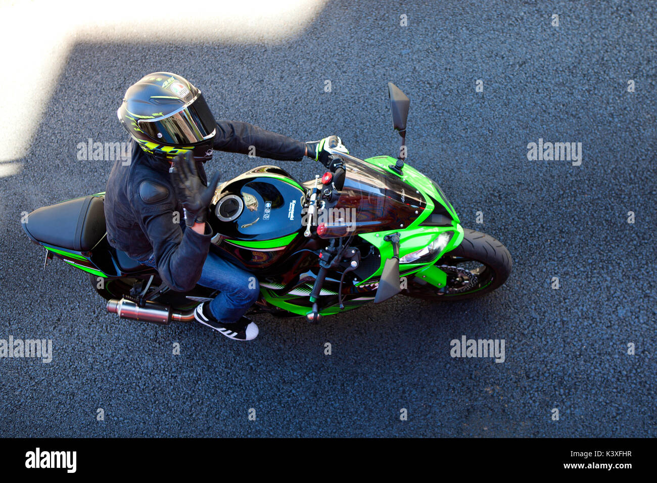 Motorcyclist on a Kawasaki Ninja 650 motorbike waving Stock Photo - Alamy