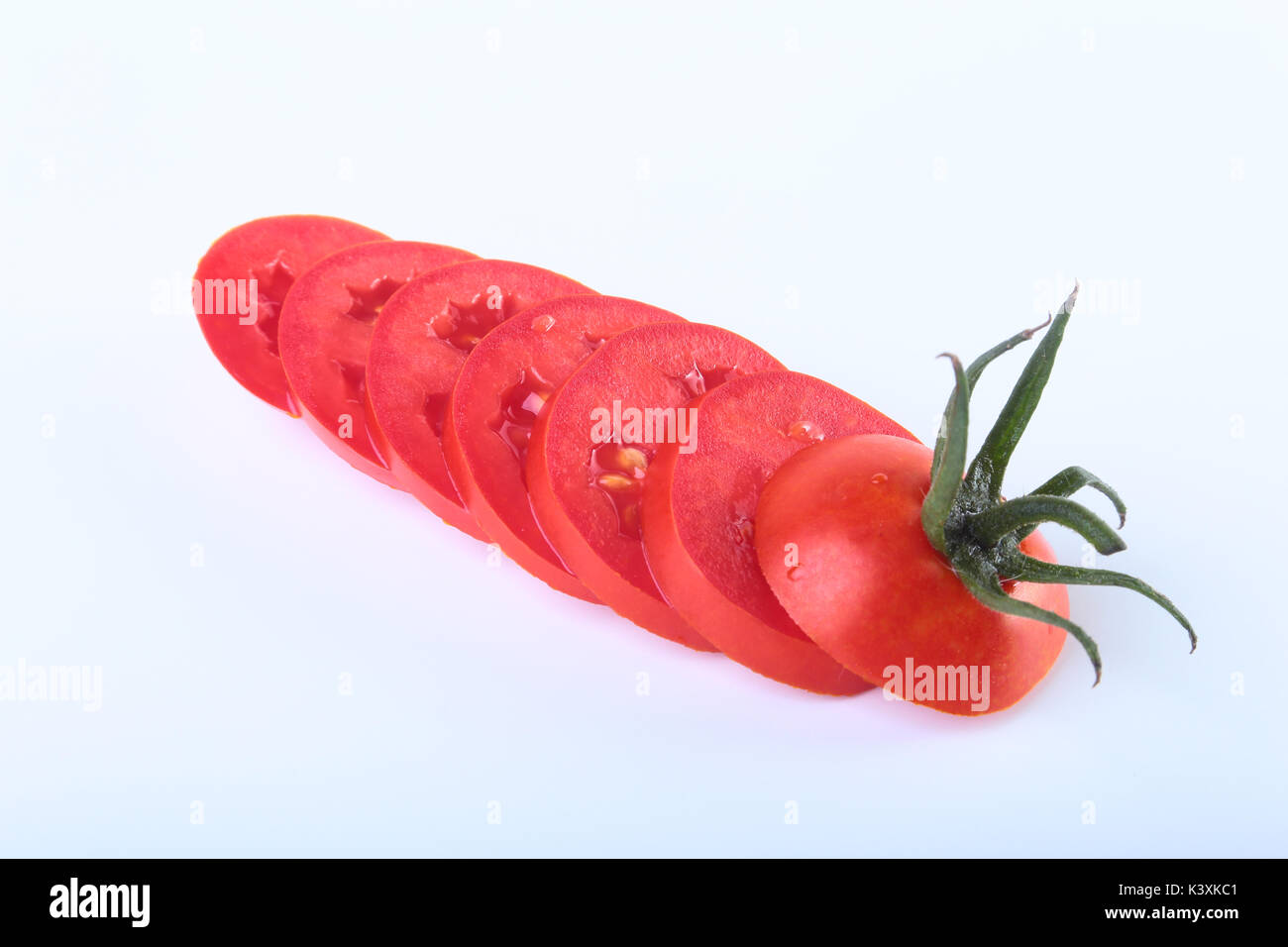 sliced fresh tomatoes with green leaves isolated on white background ...