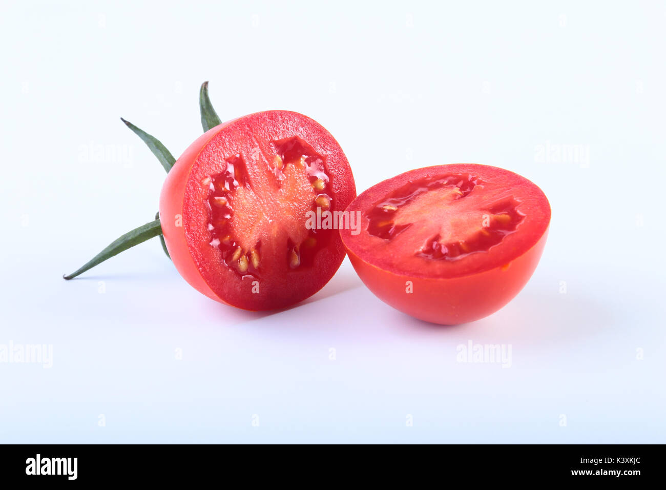 sliced fresh tomatoes with green leaves isolated on white background ...