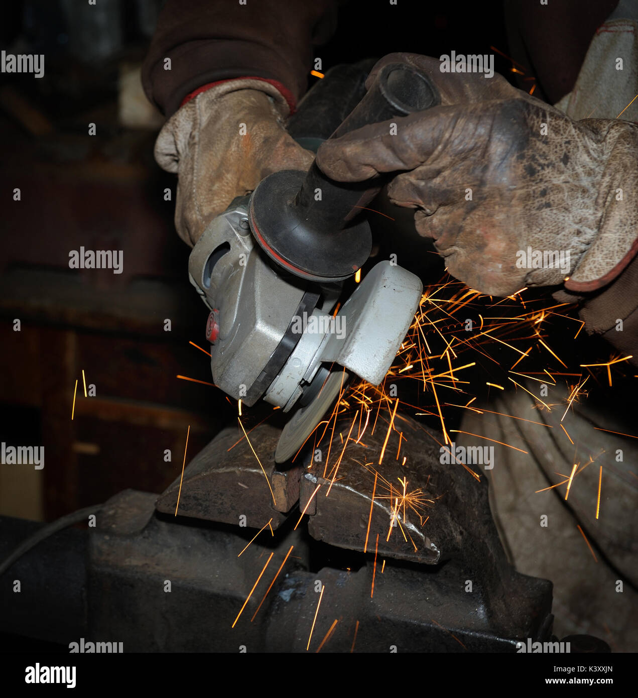 Heavy industry worker cutting steel with angle grinder Stock Photo - Alamy