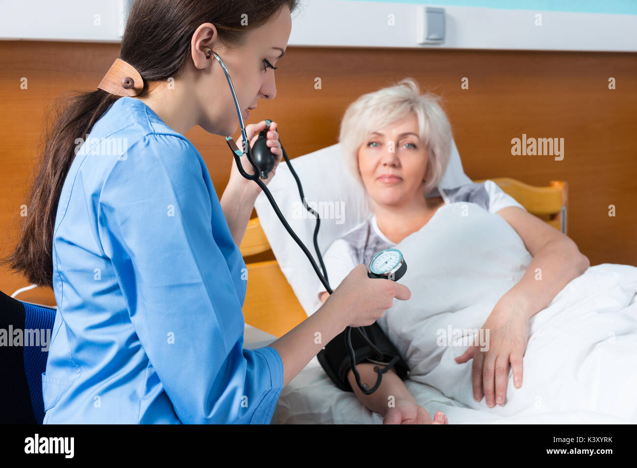 Attractive female doctor in uniform with phonendoscope is measuring the ...