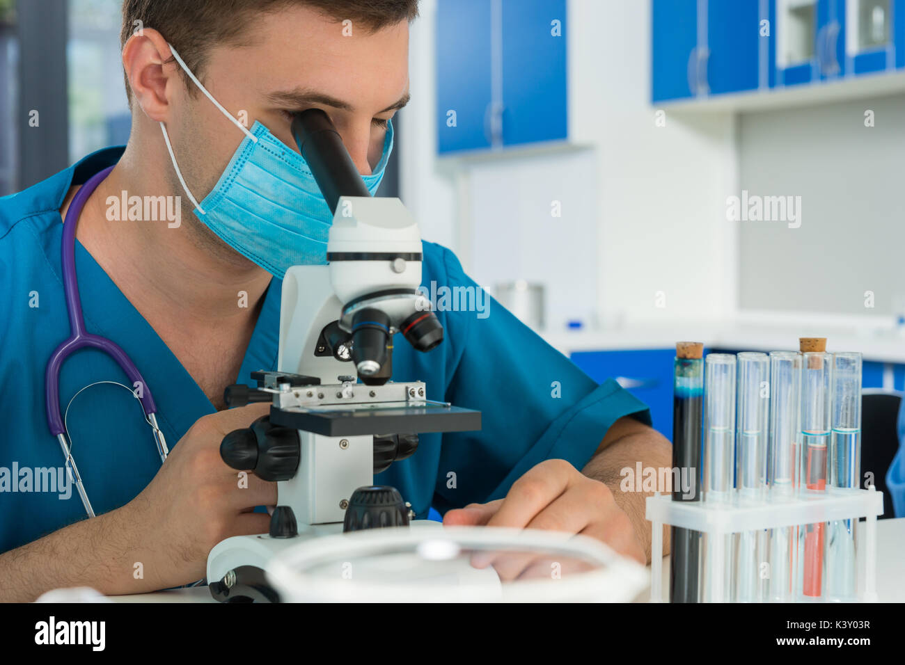 Scientist or doctor in uniform with phonendoscope on his neck is ...