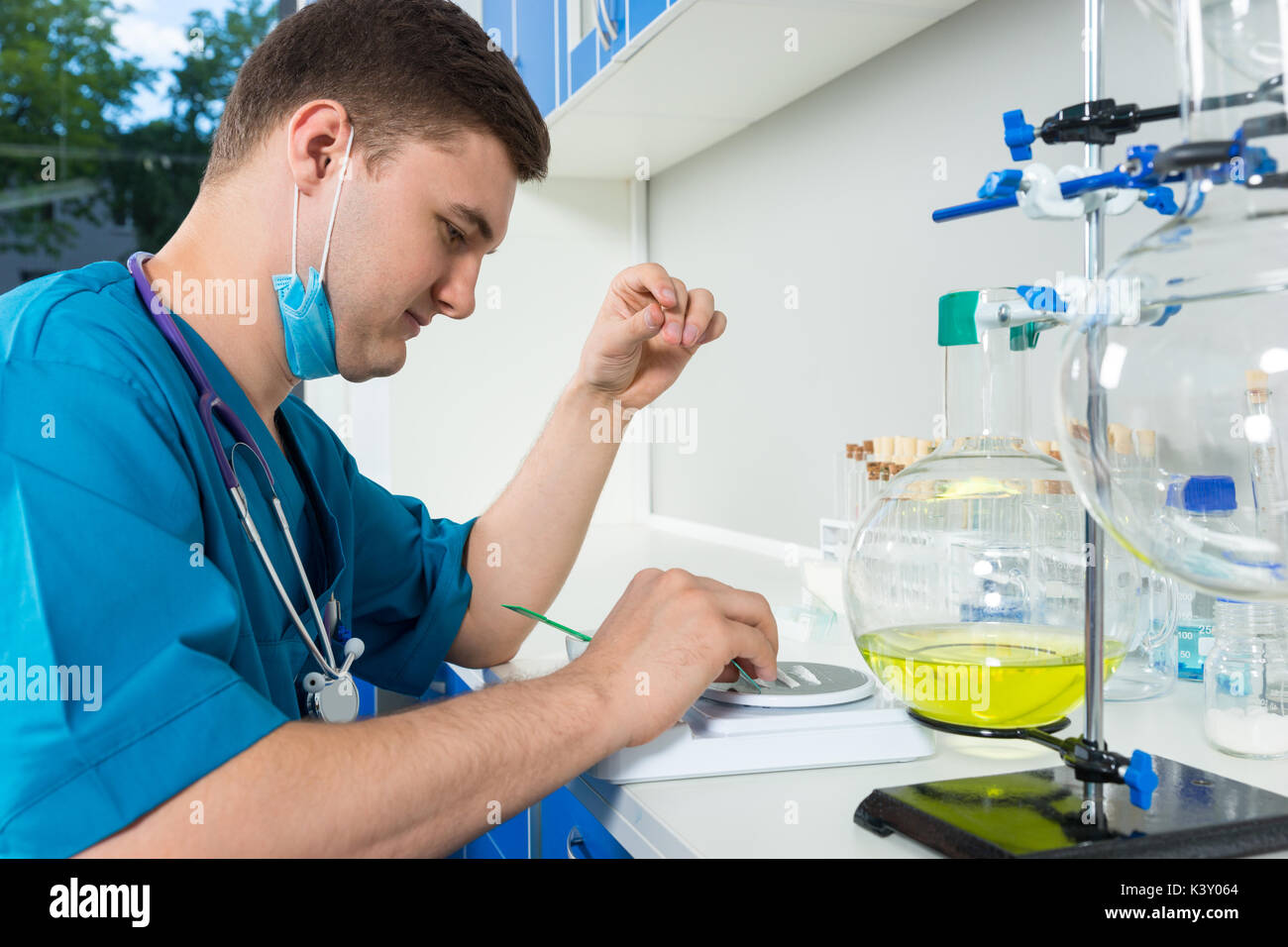 Scientist in uniform wearing a mask making tracks from powder simple to ...