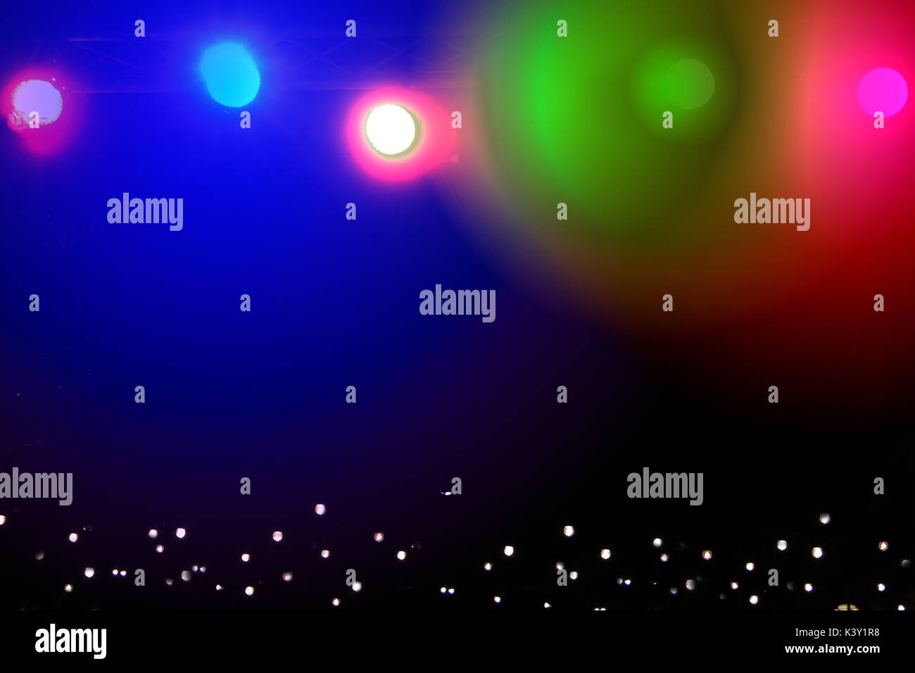 Spot lights and focus in a stage during a live show. Colored background ...