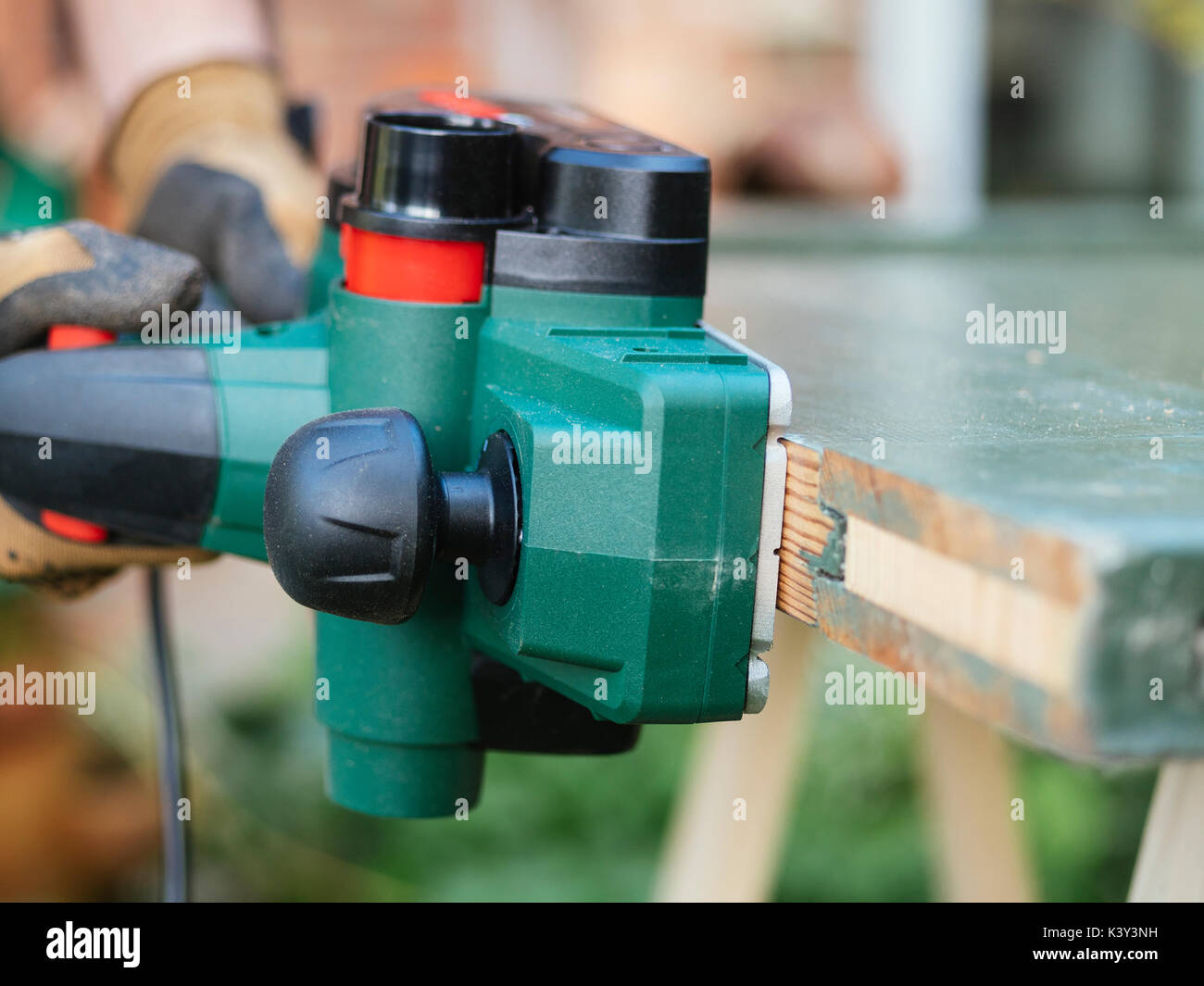 Carpenter planning the bottom of a door with an electric planner Stock ...