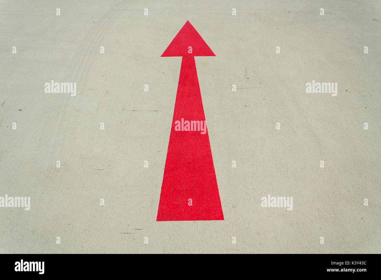 Red arrow direction sign on gray concrete road sunny day Stock Photo ...