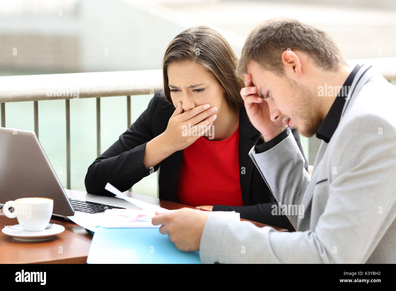 Two worried executives reading documetns complaining after discover a ...