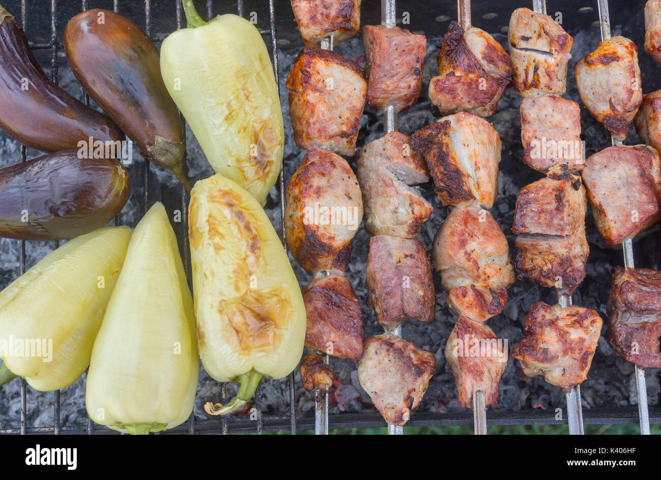 Pieces of pork meat with vegetables cooked outdoor on smouldering ...