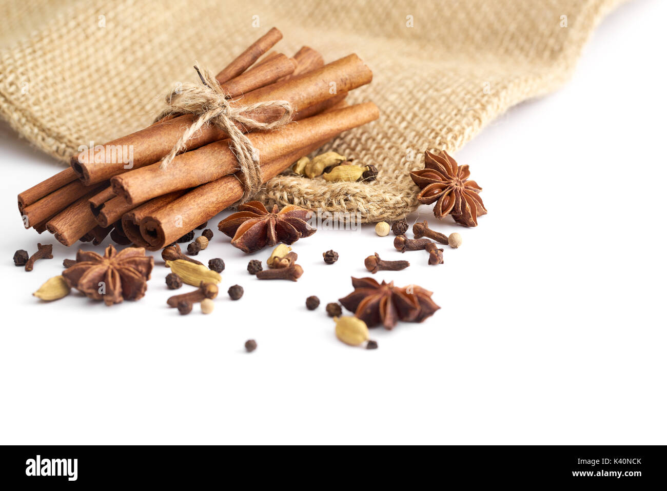 Spices and burlap sack on white background Stock Photo - Alamy