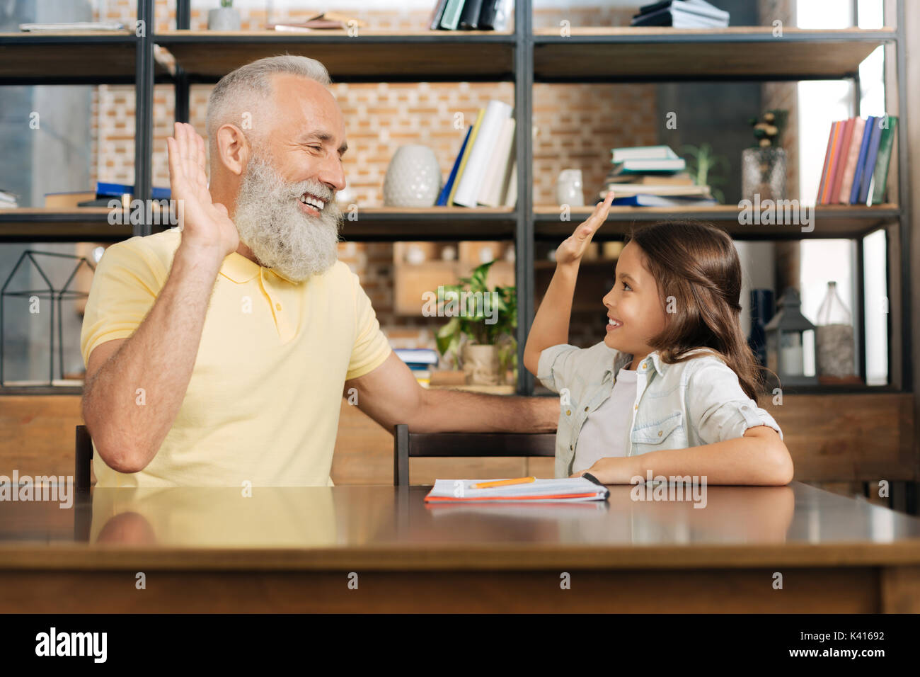 Cute little girl and grandfather high-fiving each other Stock Photo - Alamy