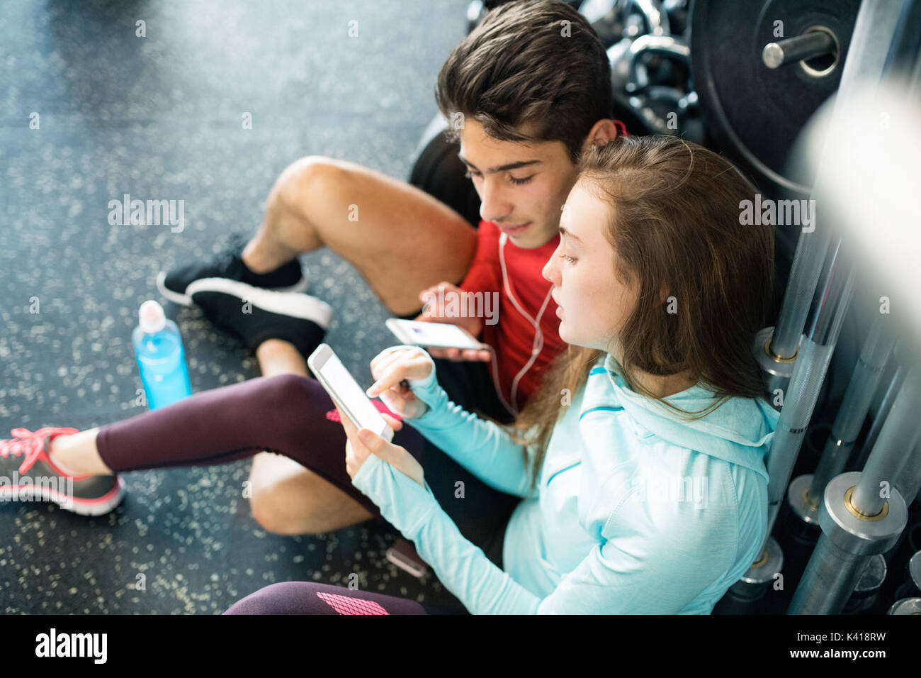 Fit couple in modern crossfit gym with smartphone Stock Photo - Alamy