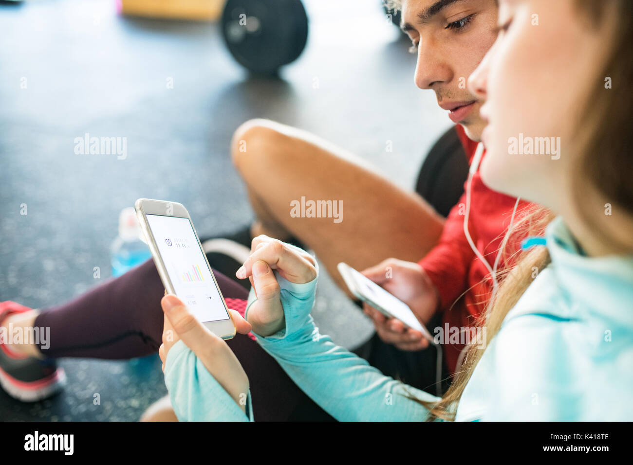 Fit couple in modern crossfit gym with smartphone Stock Photo - Alamy
