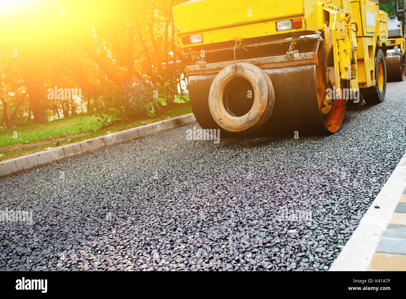 Carrying out repair works: asphalt roller stacking and pressing hot lay ...