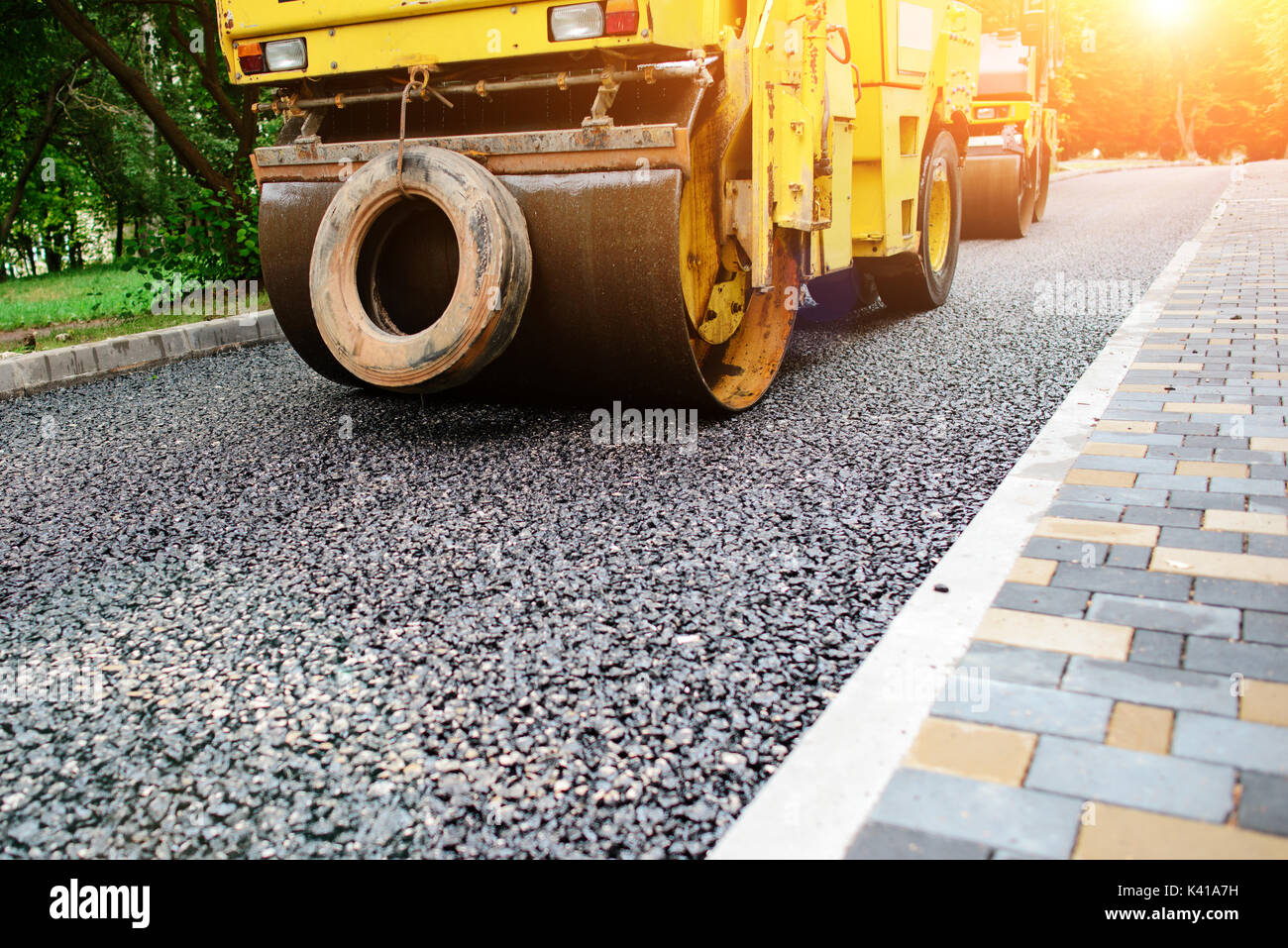 Carrying out repair works: asphalt roller stacking and pressing hot lay ...