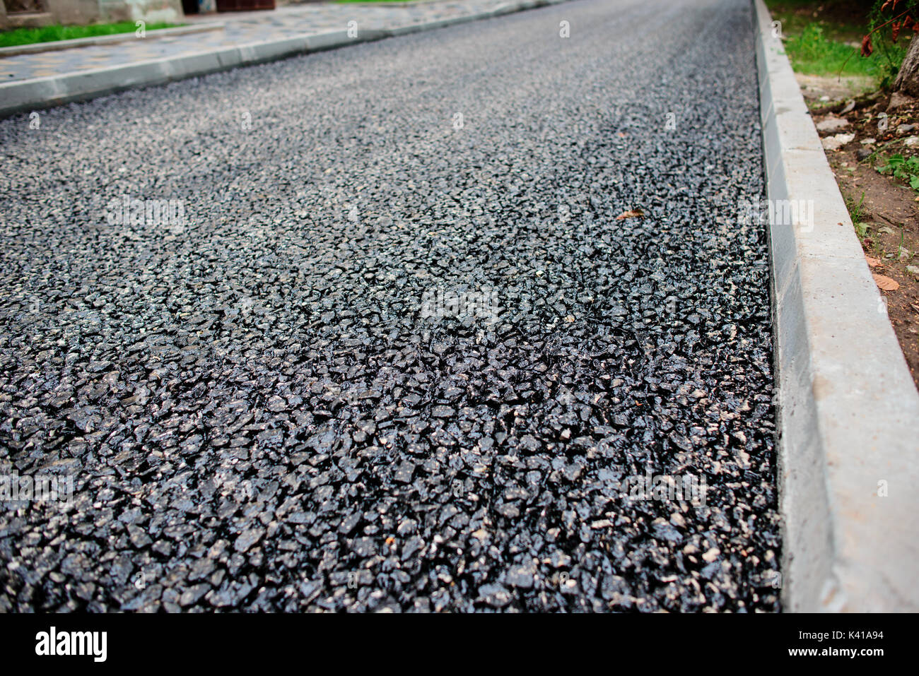 Background of black granules of fresh asphalt that been already paved ...