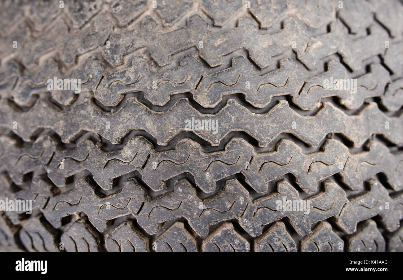 Texture of thick-skinned rubber tire colored in dark gray with carved ...