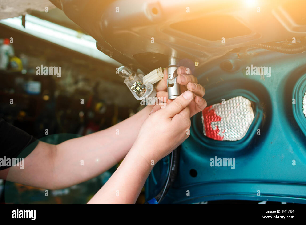 Closeup repairing of an broken blue car in garage by hands of machanic ...